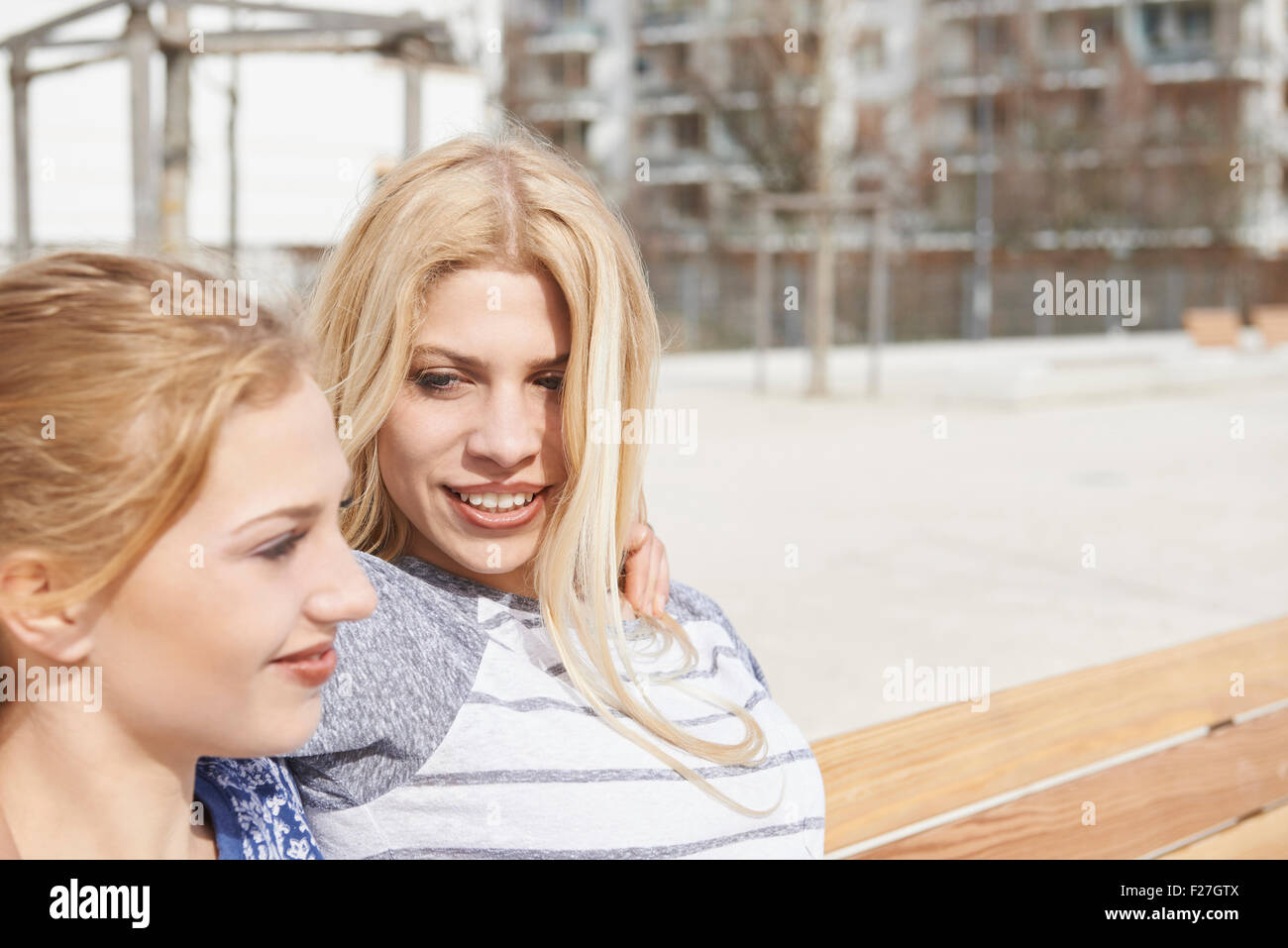 Two friends sitting on a bench in a playground, Munich, Bavaria ...