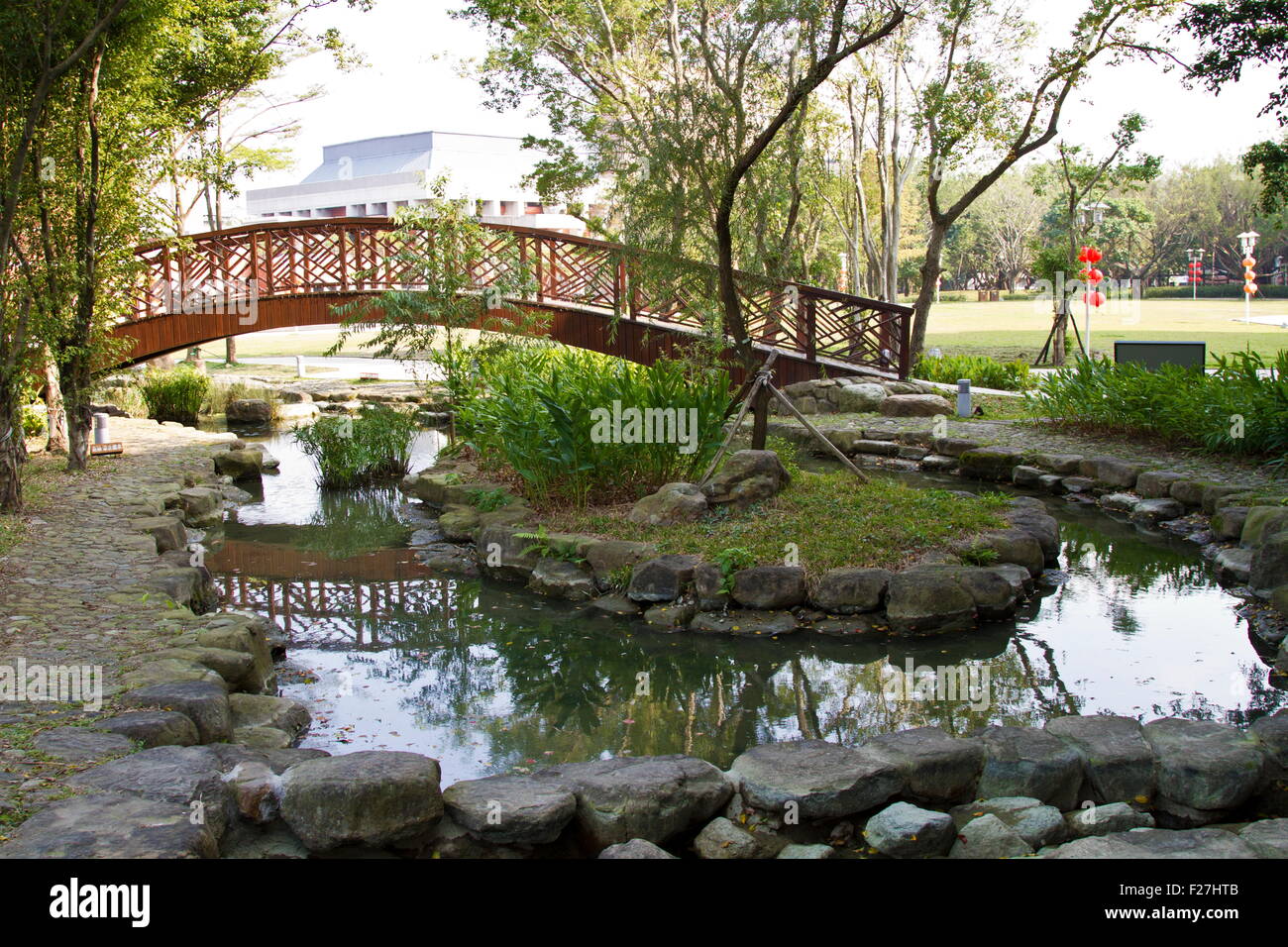 bridge across stream in green park Stock Photo - Alamy