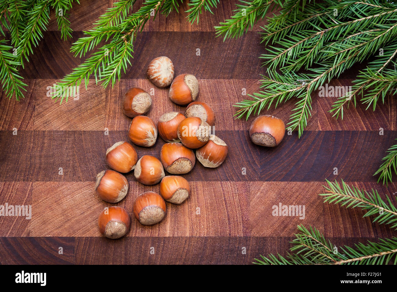 Wood background with hazelnuts and fir tree Stock Photo - Alamy