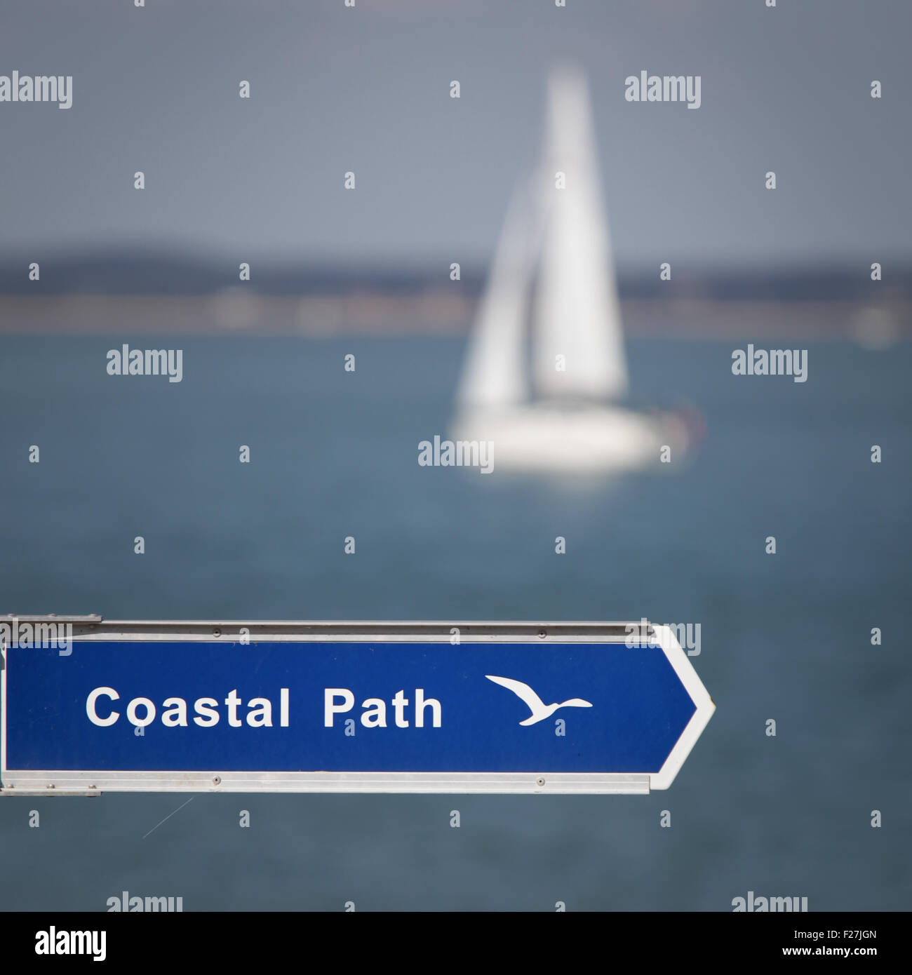 A coastal path sign with a sailing yacht in the background Stock Photo ...