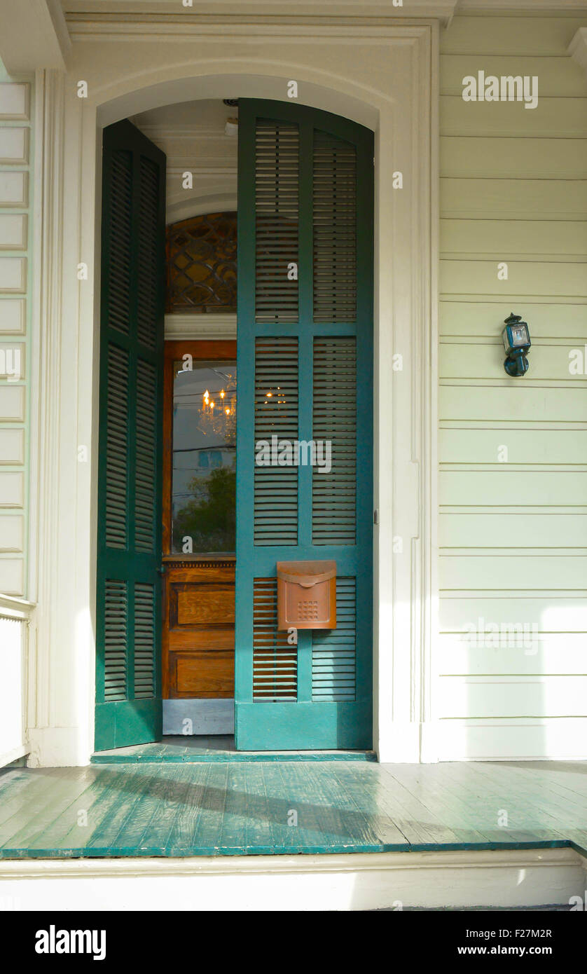 A partially opened shuttered door with letterbox reveals a gleaming ...