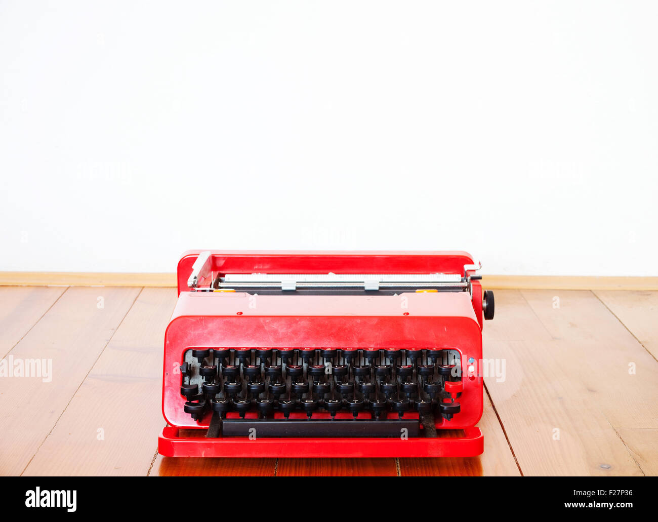 Old red typewriter wooden floor Stock Photo - Alamy