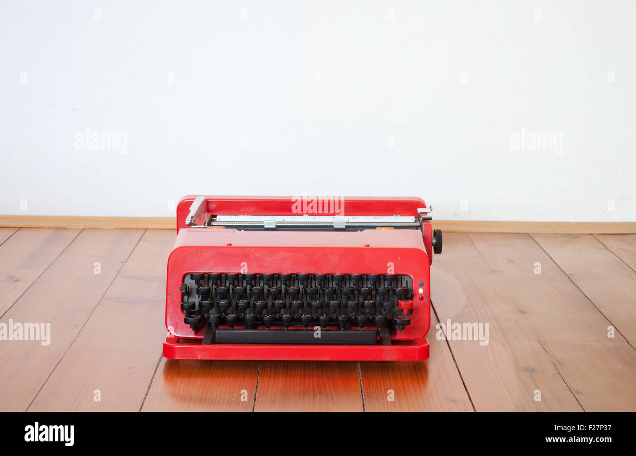 Old red typewriter wooden floor Stock Photo - Alamy