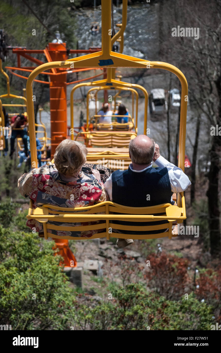 An adult couple rides down the chair lift from an overlook in the ...