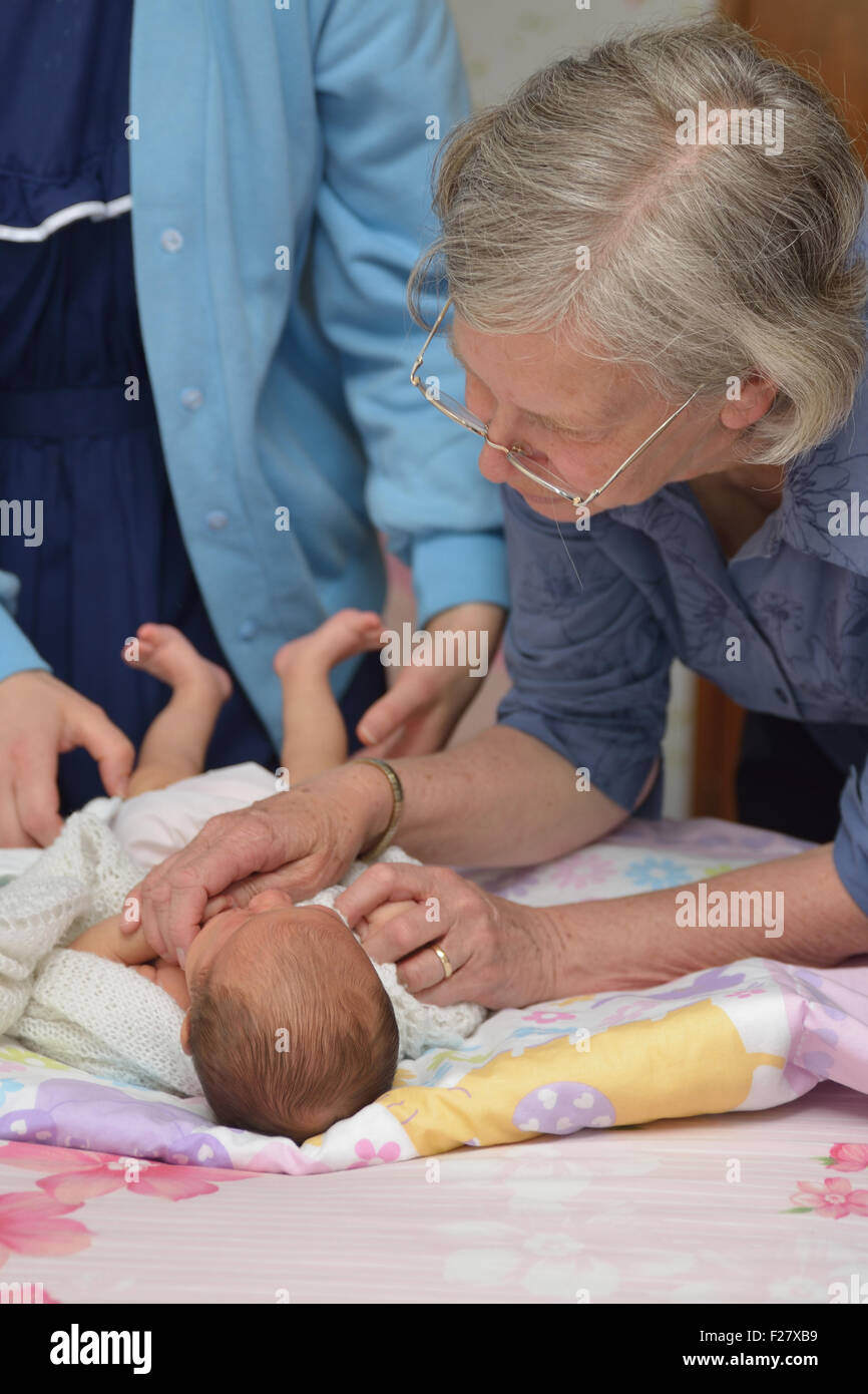 A senior midwife checks a newborn baby with her mother Stock Photo - Alamy