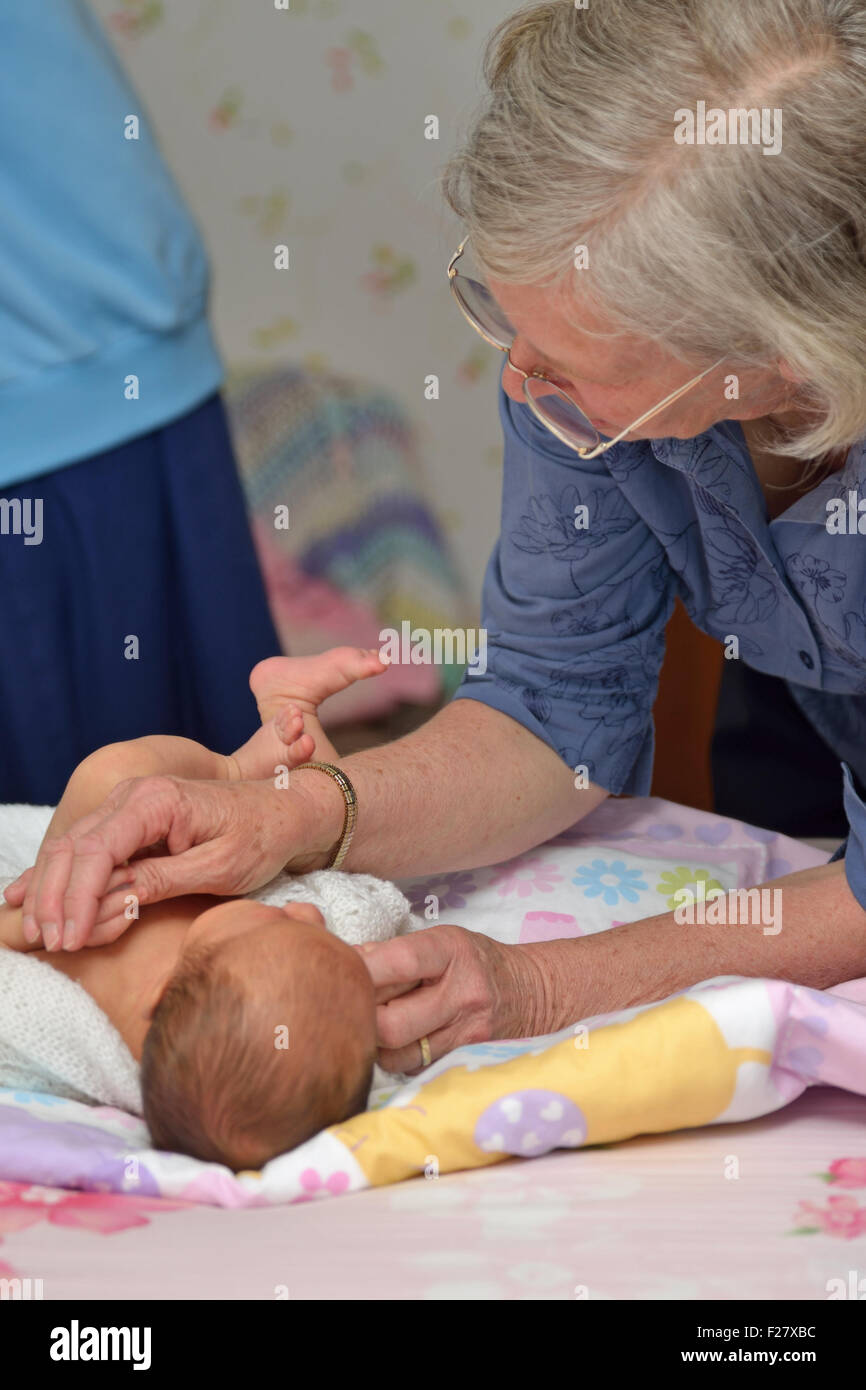 A senior midwife checks a newborn baby with her mother Stock Photo - Alamy