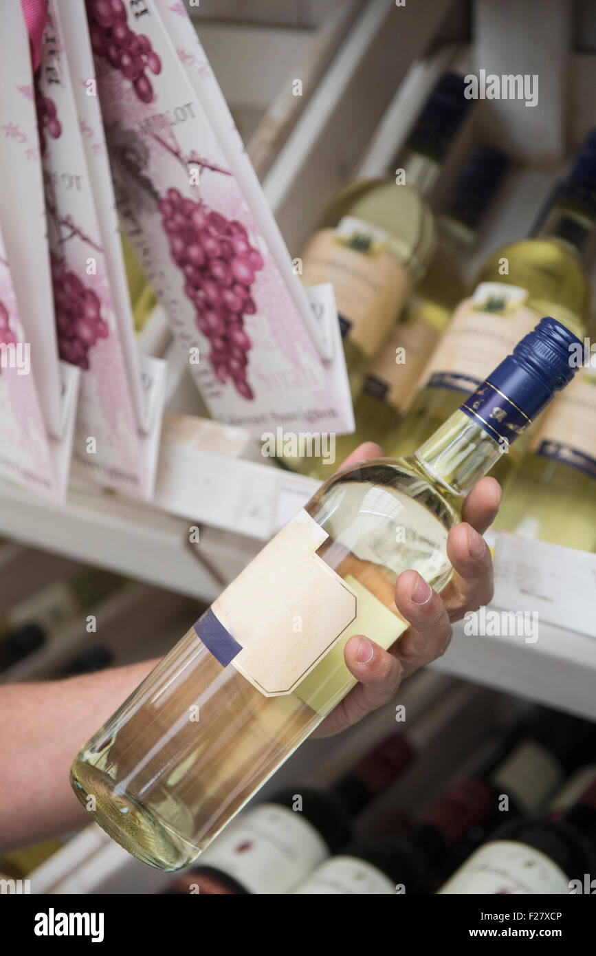 Customer reading label on a wine bottle in supermarket, Augsburg ...