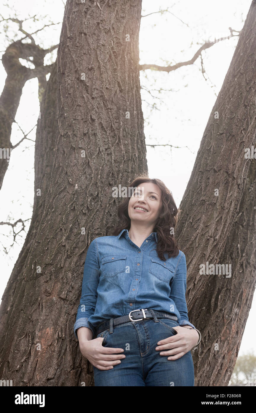 Mature woman leaning against tree in park, Bavaria, Germany Stock Photo ...