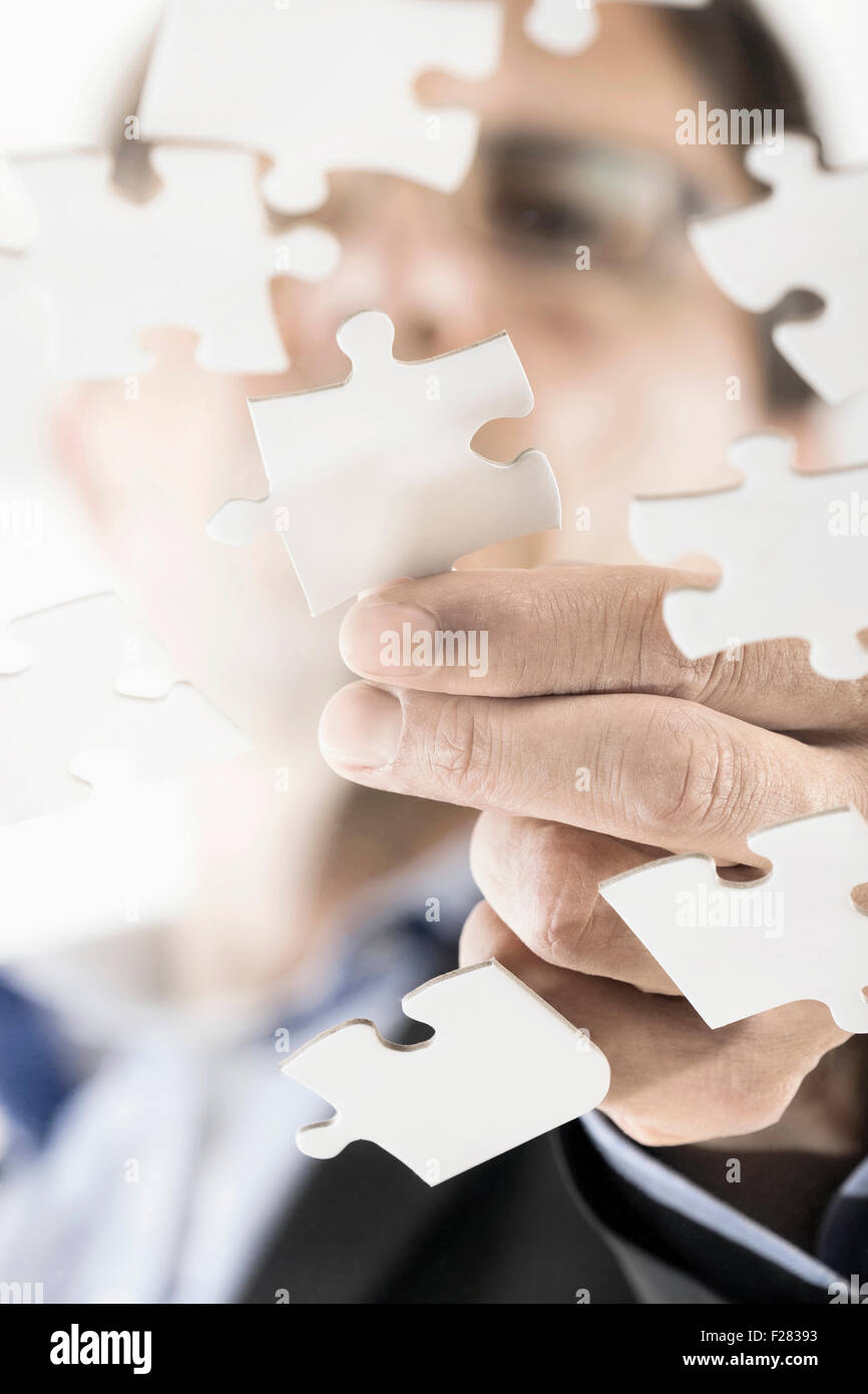 businessman arranging jigsaw puzzle pieces, Bavaria, Germany Stock ...