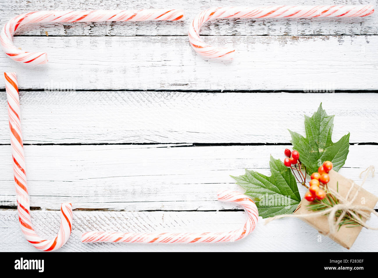 Christmas frame made up of candy canes and small package with guelder ...