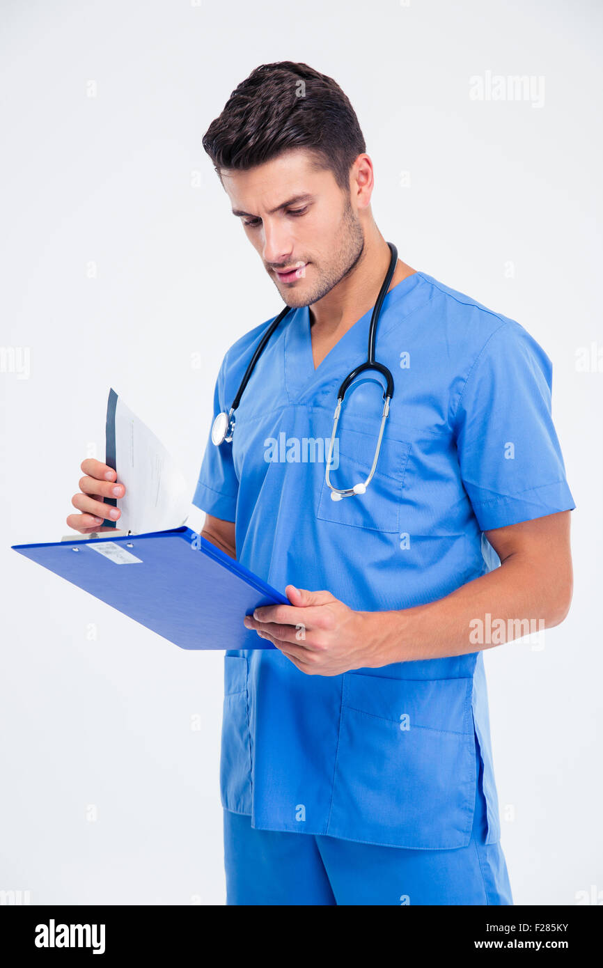 Portrait of a male doctor reading clipboard isolated on a white ...