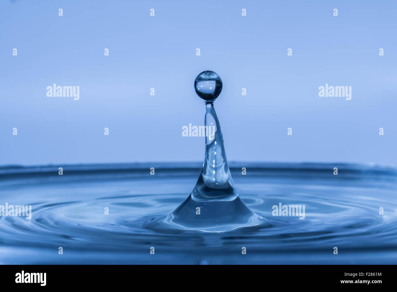 Drop of water falling on water level Stock Photo - Alamy