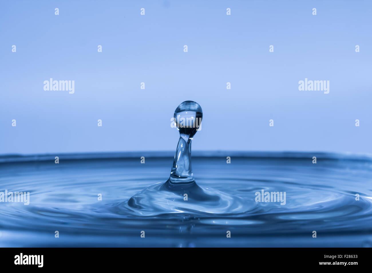 Drop of water falling on water level Stock Photo - Alamy
