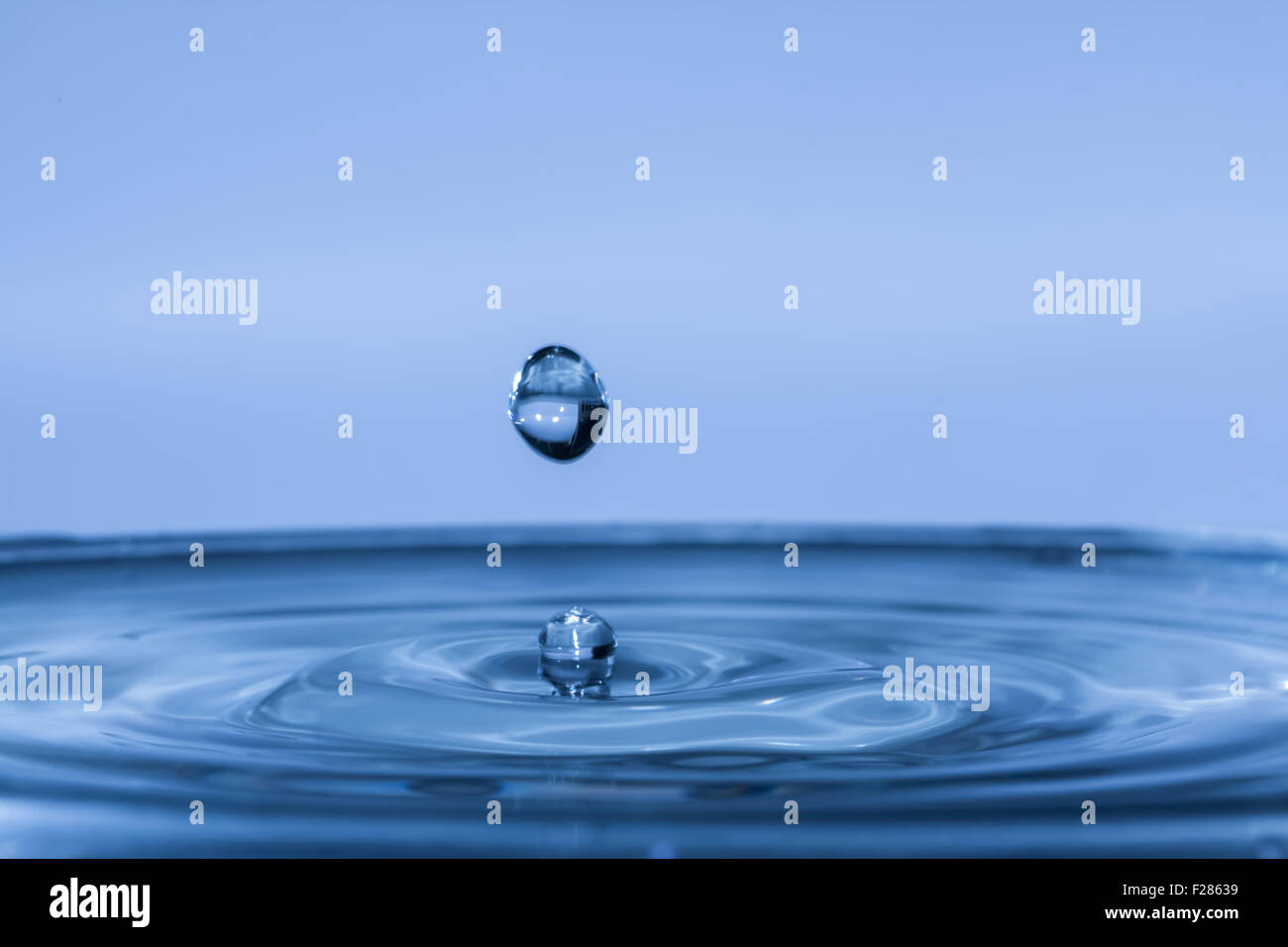 Drop of water falling on water level Stock Photo - Alamy