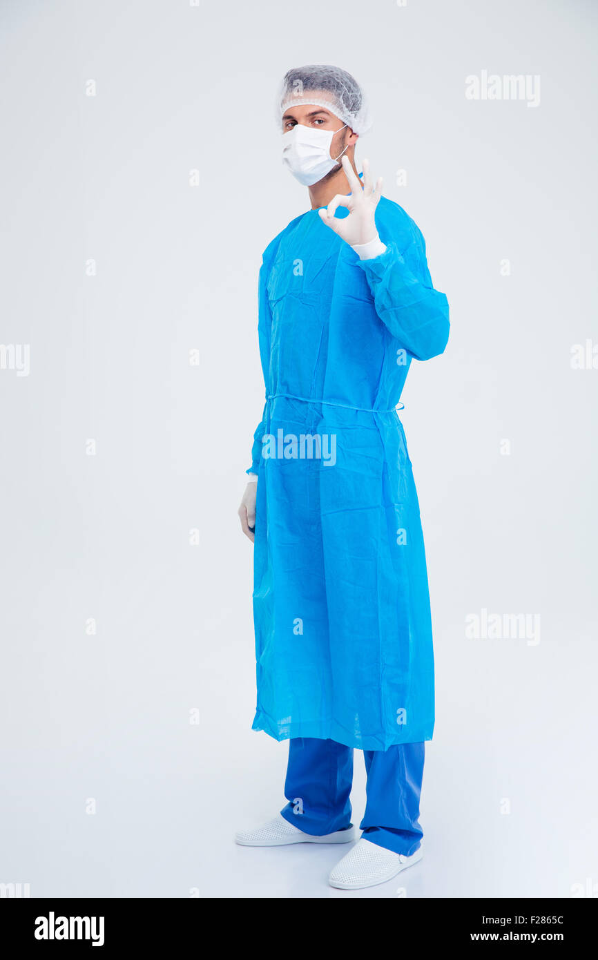Full length portrait of a male surgeon showing ok sign isolated on a ...