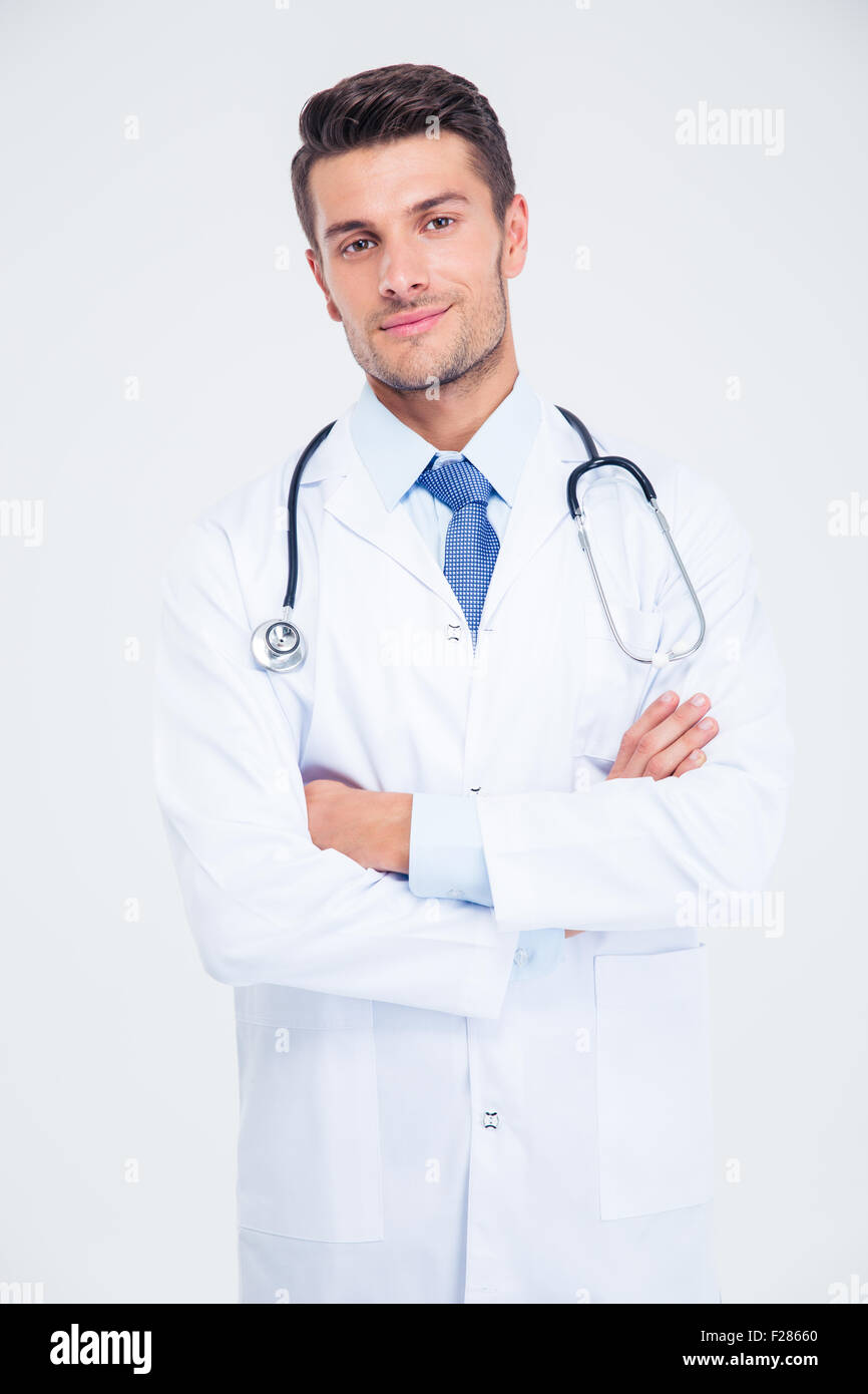 Portrait of a handsome male doctor standing with arms folded isolated ...