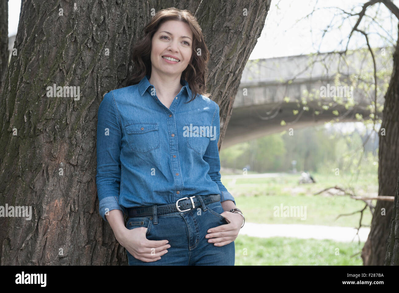 Mature woman leaning against tree in park, Bavaria, Germany Stock Photo ...