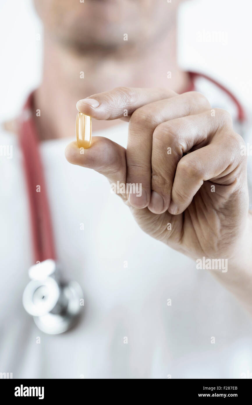 Male doctor showing a capsule of dietary supplement, Bavaria, Germany ...