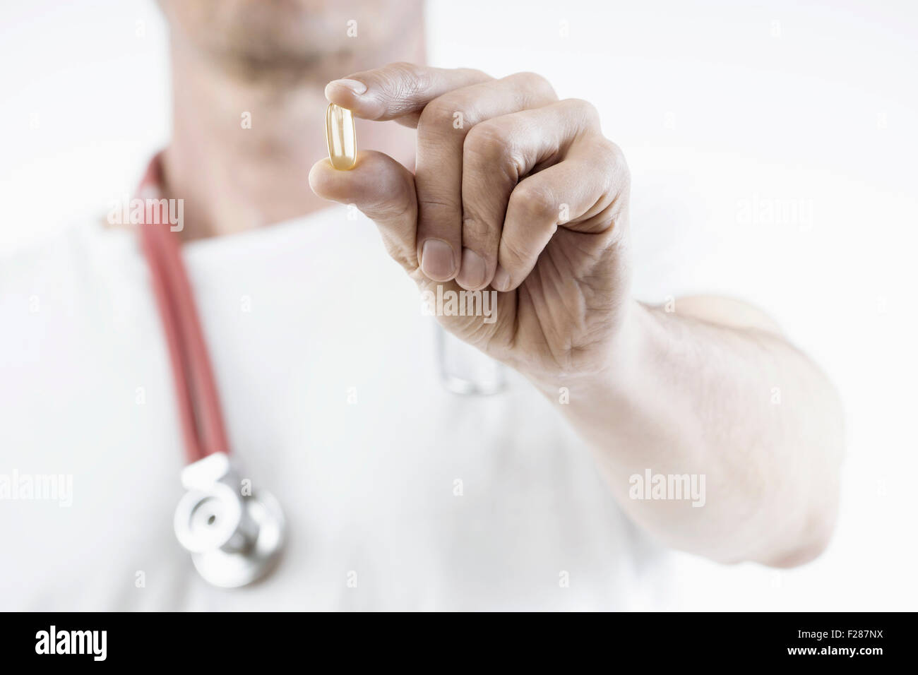 Male doctor showing a capsule of dietary supplement, Bavaria, Germany ...