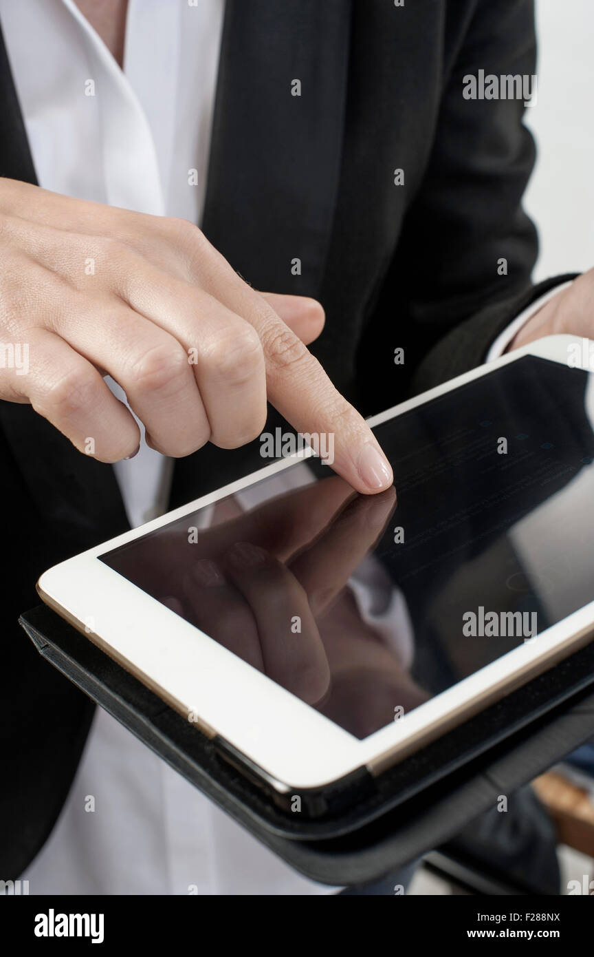 Midsection view of businesswoman operating digital tablet in office ...