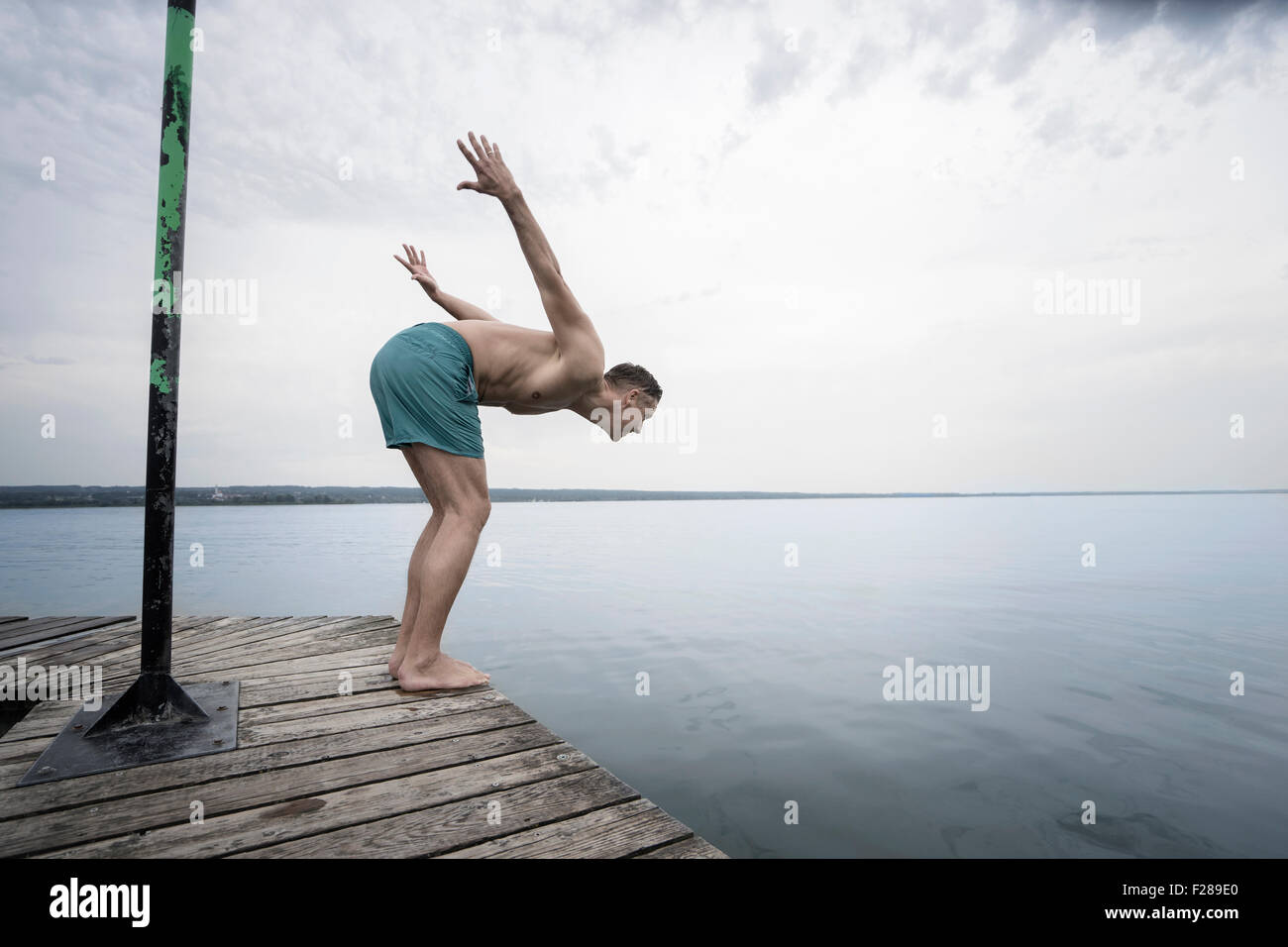 Mature man diving into water on pier, Baden-Wurttemberg, Bavaria ...