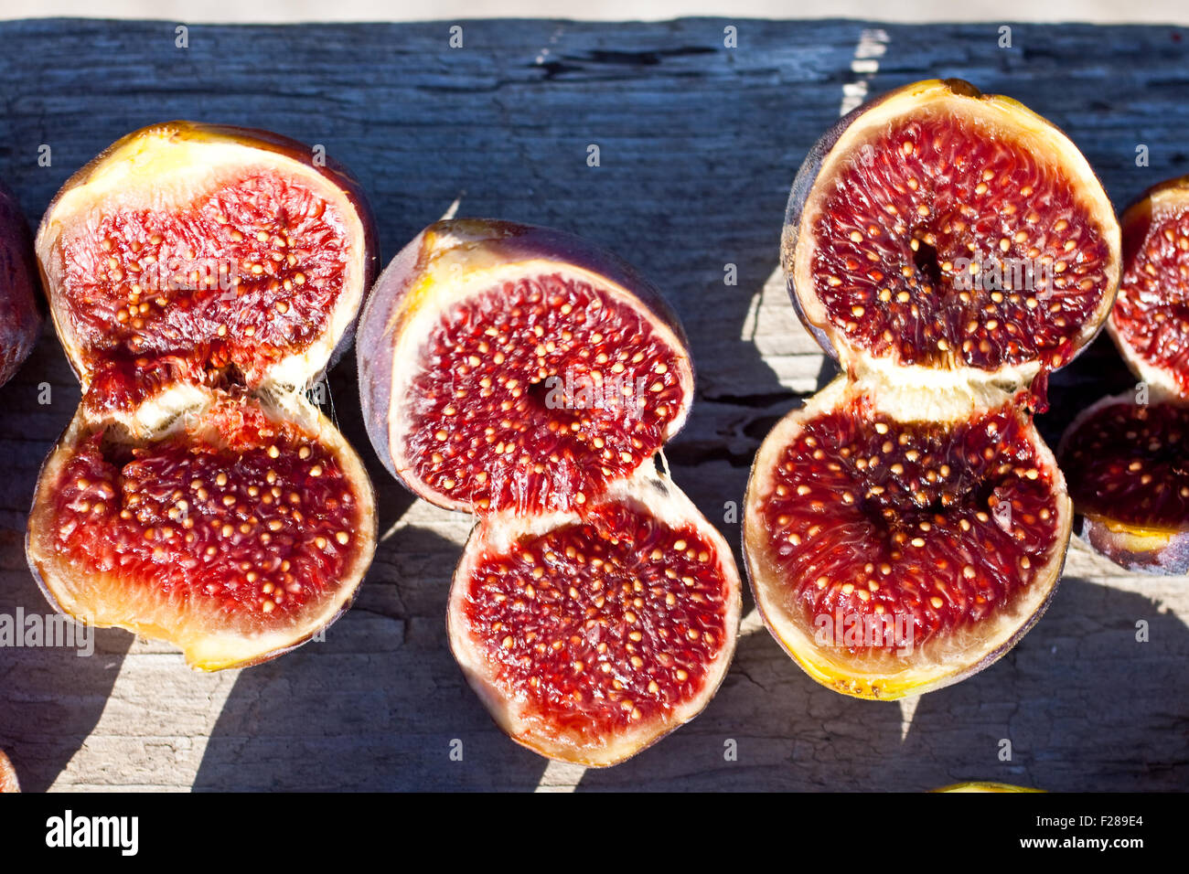 Open figs on wooden surface Stock Photo - Alamy