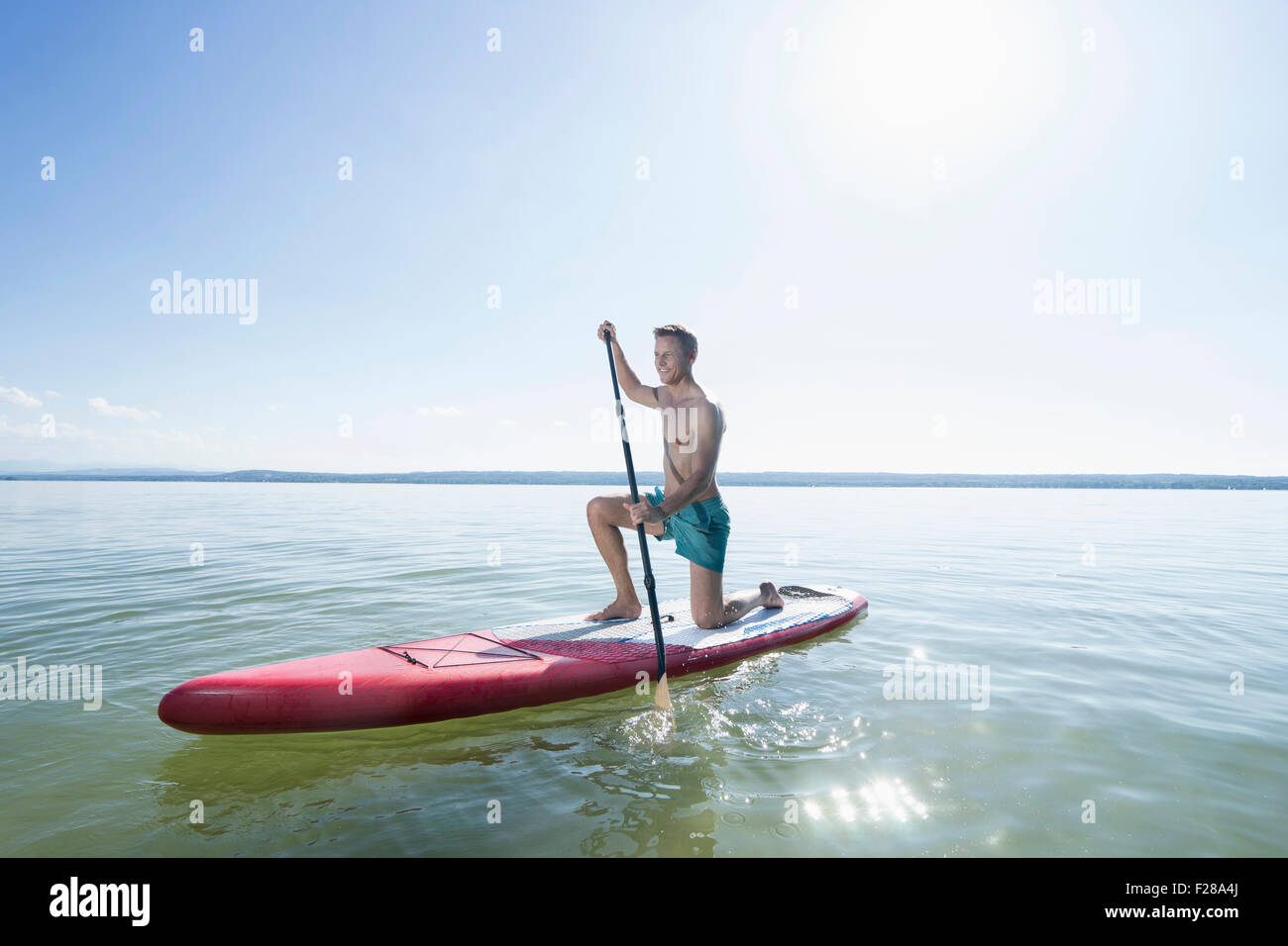 Mature man paddleboarding in the lake, Bavaria, Germany Stock Photo - Alamy