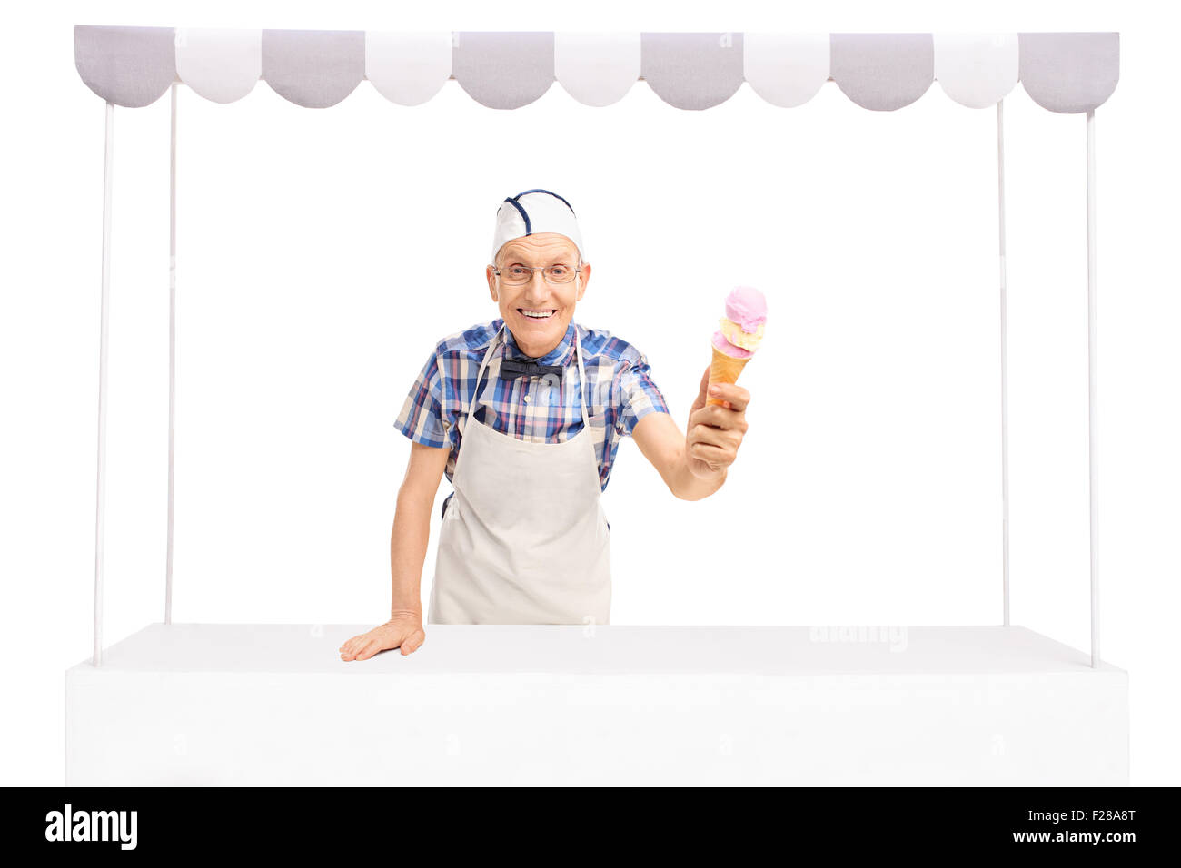 Senior ice cream vendor standing behind a stall and giving an ice cream ...