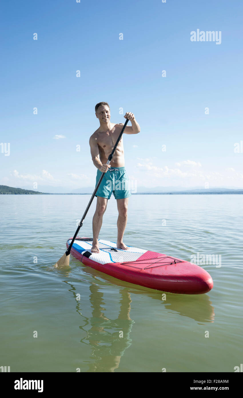 Mature man paddleboarding in the lake, Bavaria, Germany Stock Photo - Alamy