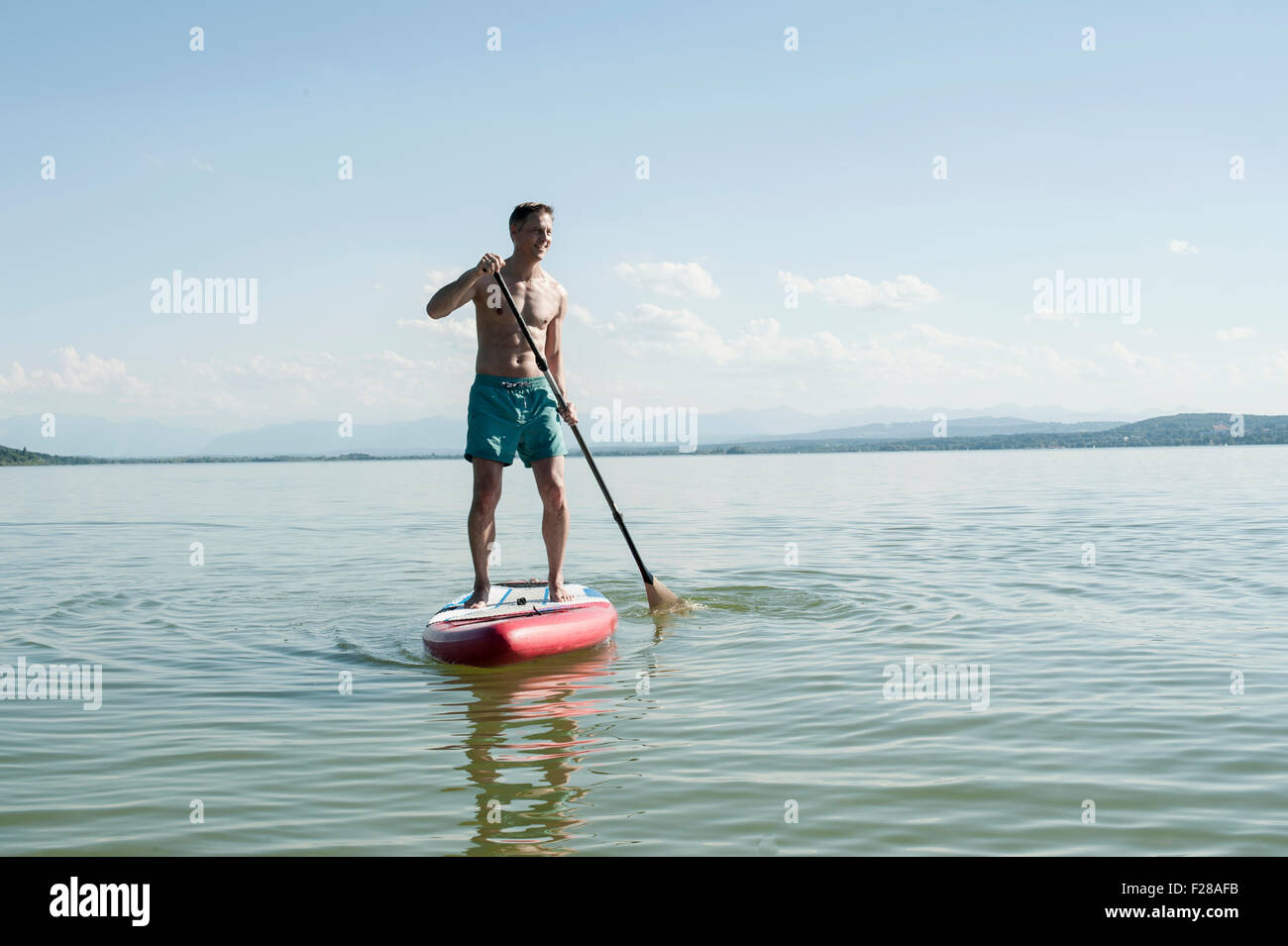 Mature man paddleboarding in the lake, Bavaria, Germany Stock Photo - Alamy