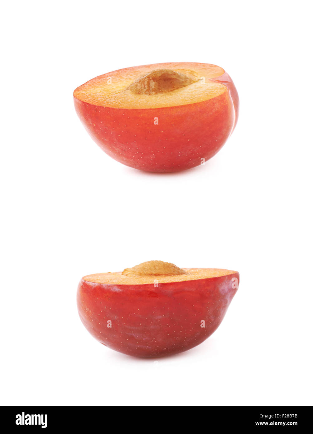 Cut open half of a red victoria plum isolated over the white background ...