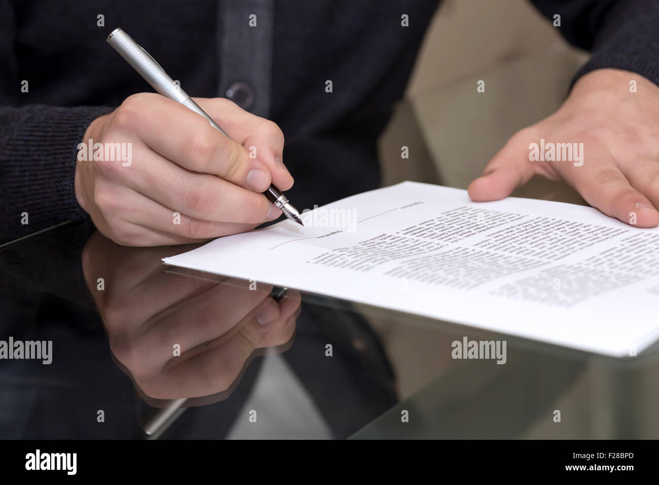 Hands of man signing formal paper Stock Photo - Alamy