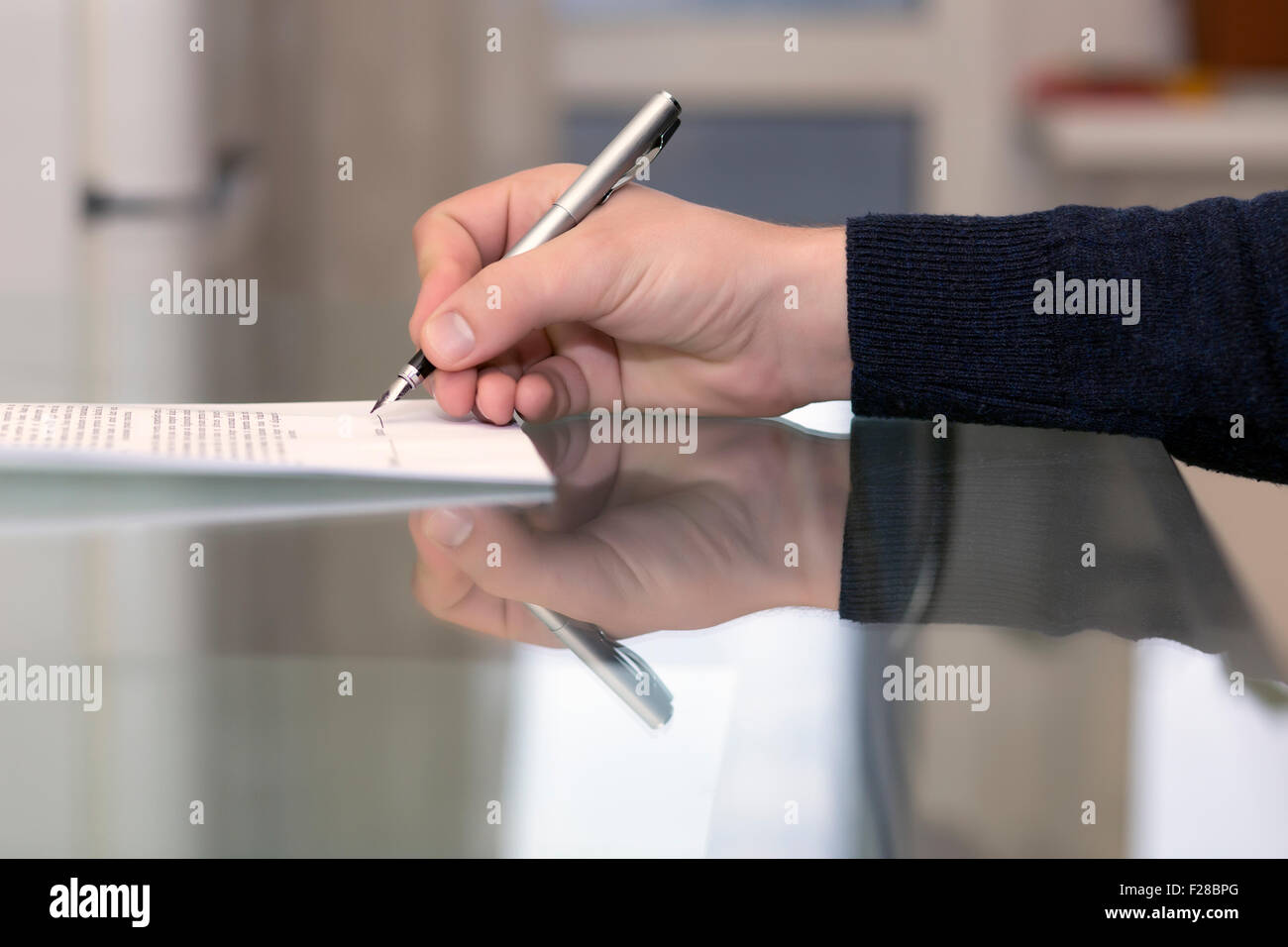 Hands of man signing formal paper Stock Photo - Alamy