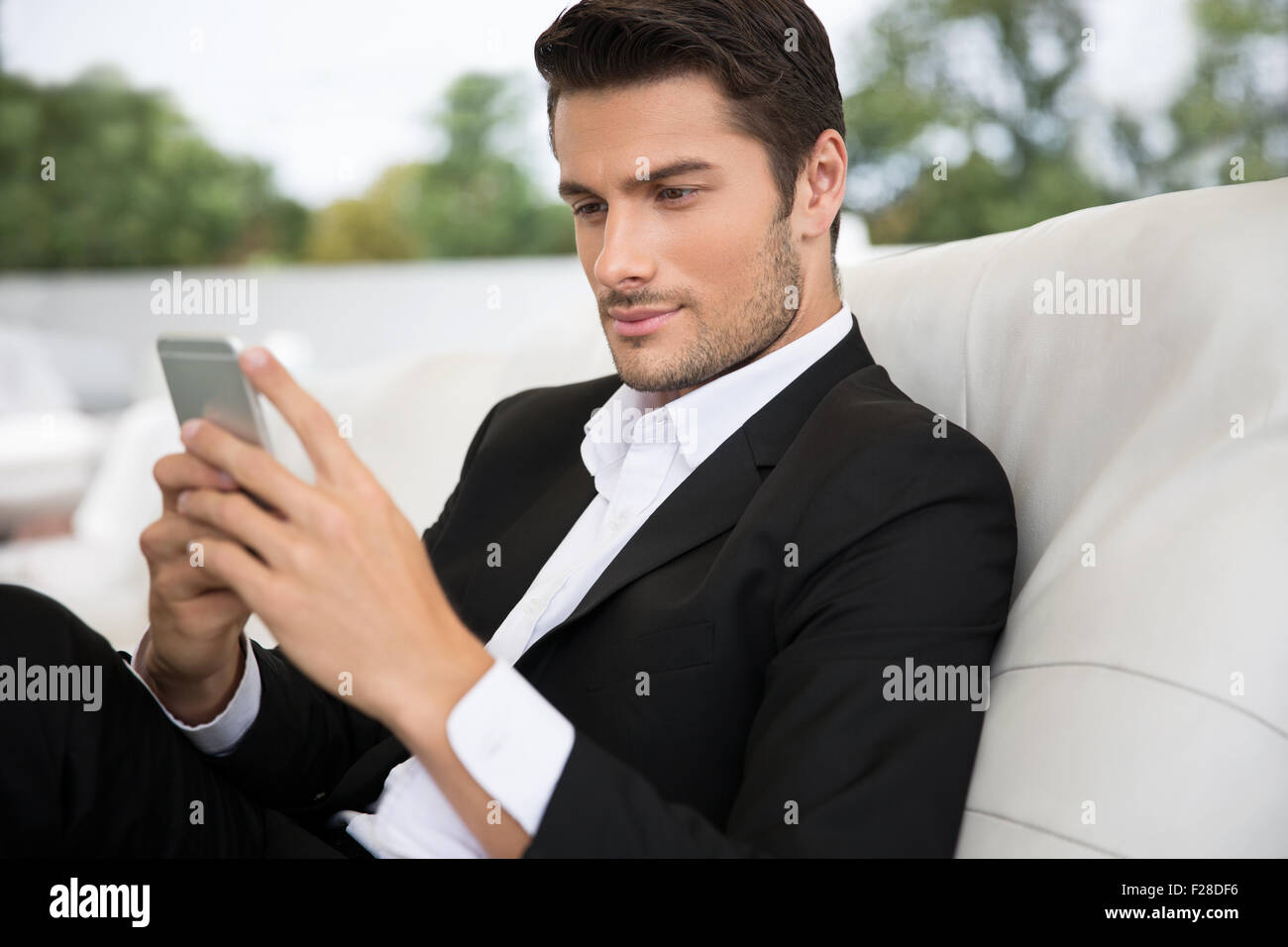 Smiling rich man holding smartphone hi-res stock photography and images ...
