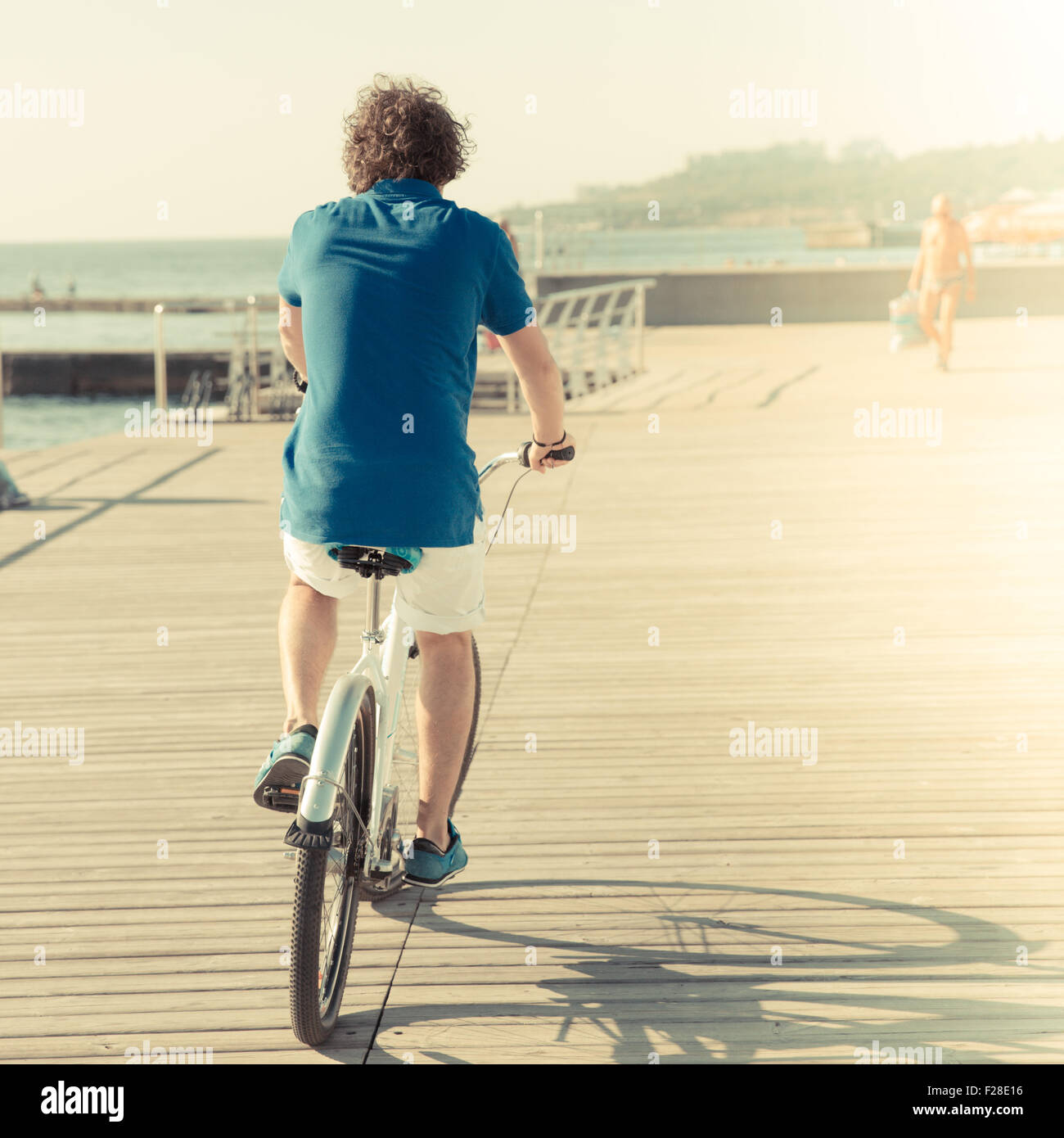 Portrait of a man riding on bicycle outdoors near the sea Stock Photo ...