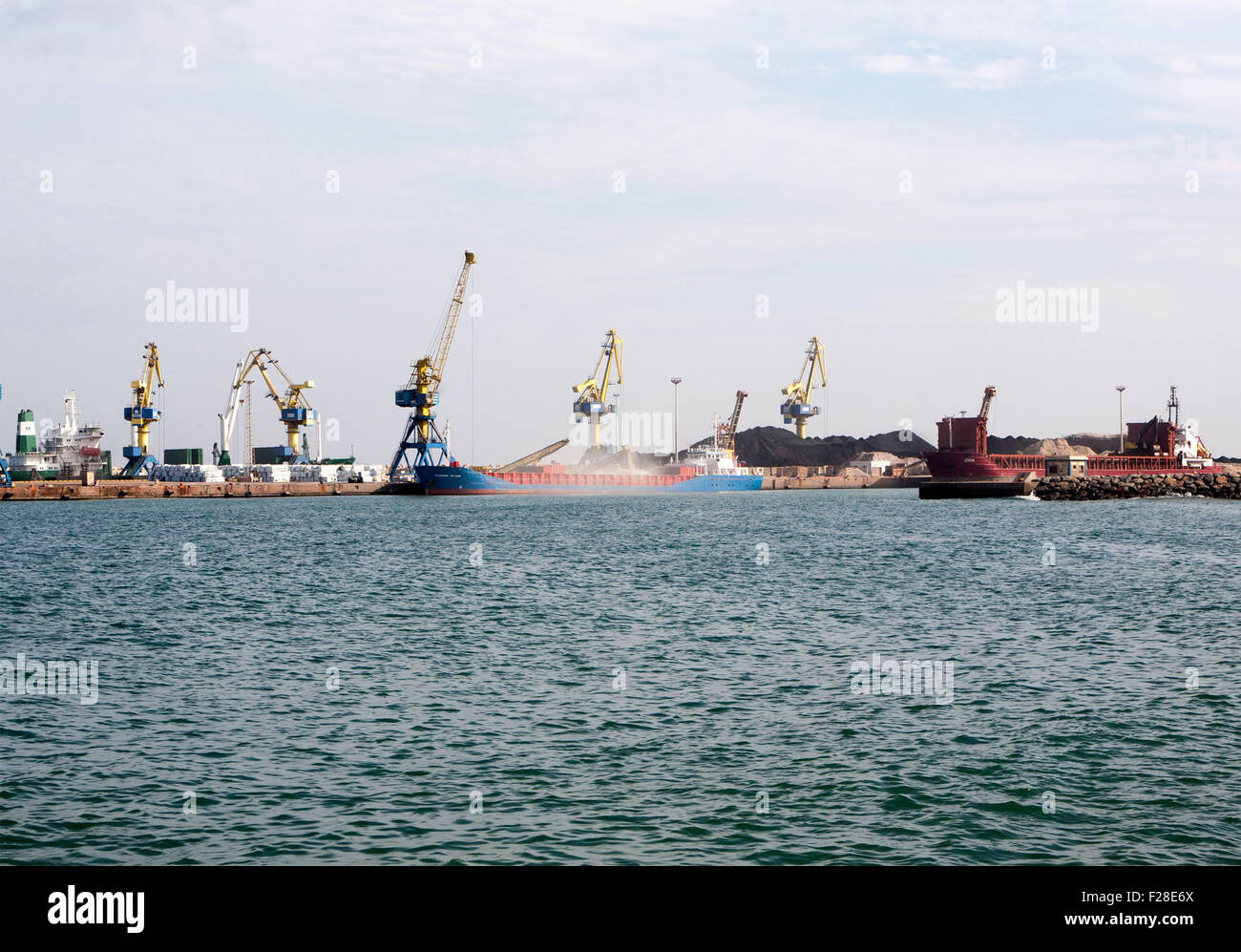 Cranes loading bulk carrier ship with rock ore at the port of Beni ...