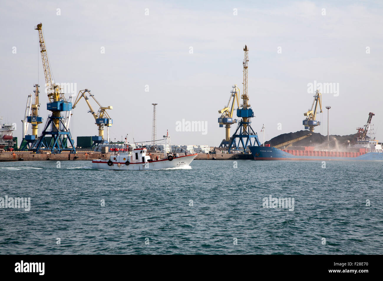 Cranes loading bulk carrier ship with rock ore at the port of Beni ...
