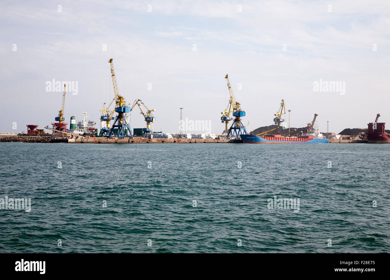 Cranes loading bulk carrier ship with rock ore at the port of Beni ...
