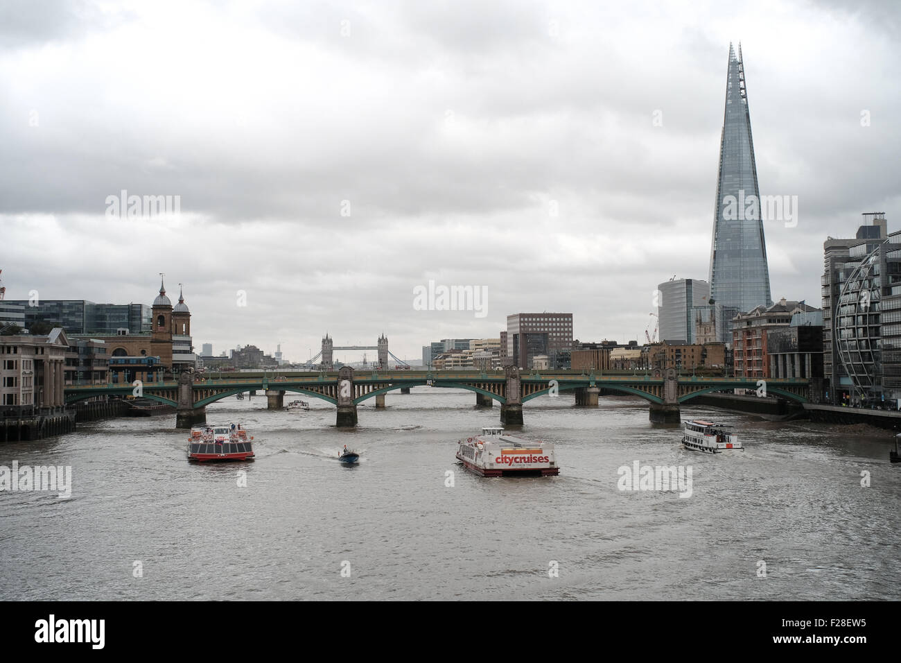 a view towards tower bridge London with a City cruises pleasure boat in ...
