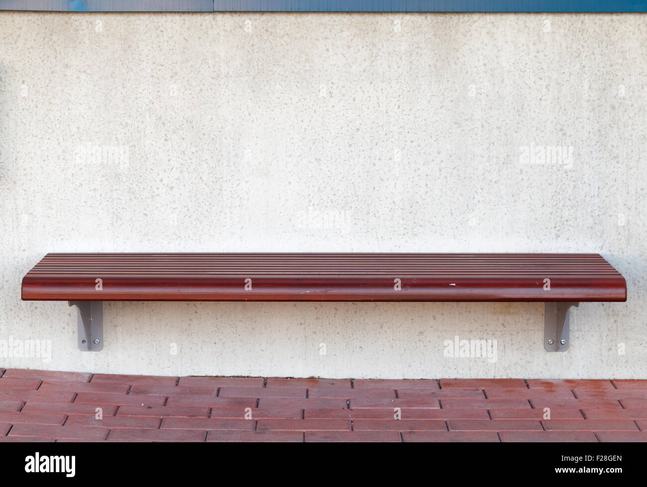 Wooden street bench mounted on white stone wall on bus stop Stock Photo ...