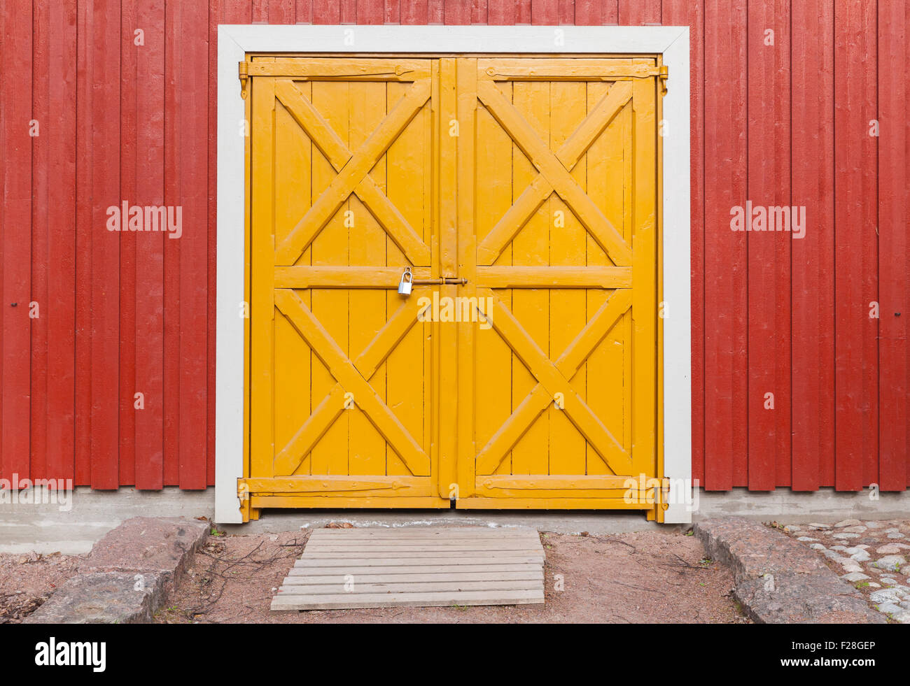 Locked yellow gate in red rural wooden wall, background photo texture ...