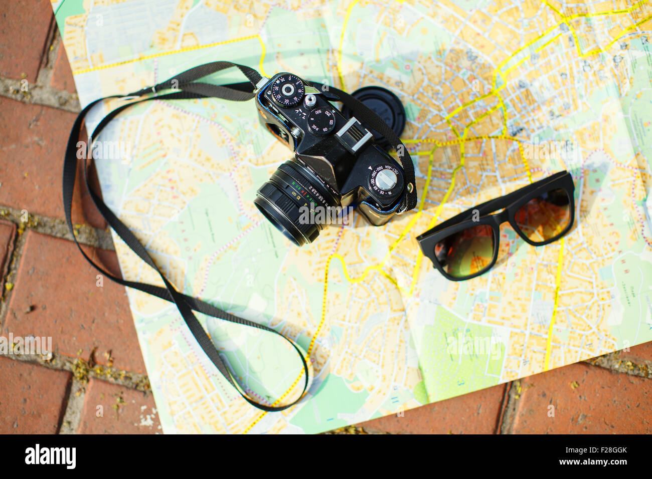 Old camera and sunglasses on the tourist map, top view Stock Photo - Alamy
