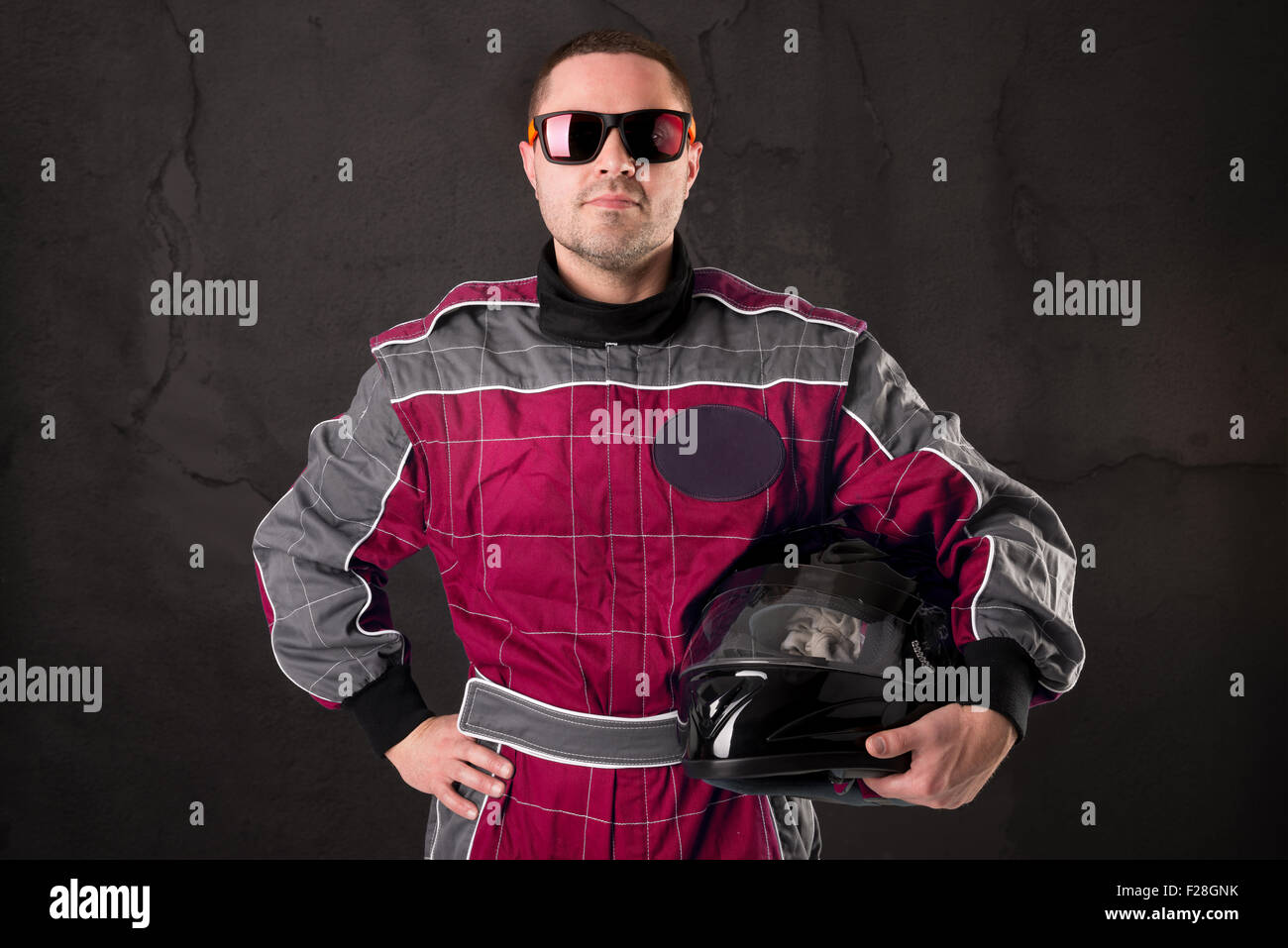 Racing driver posing with helmet over a grunge background Stock Photo ...