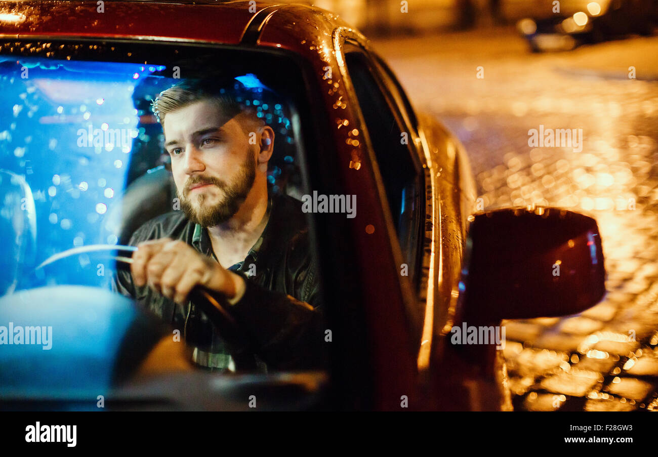 Handsome young man driving his sport car, at night Stock Photo - Alamy