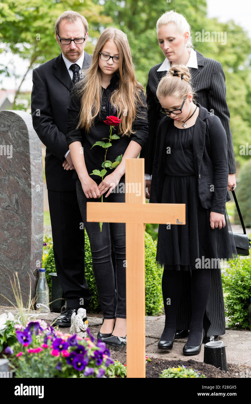 Family mourning at grave on graveyard or cemetery Stock Photo - Alamy