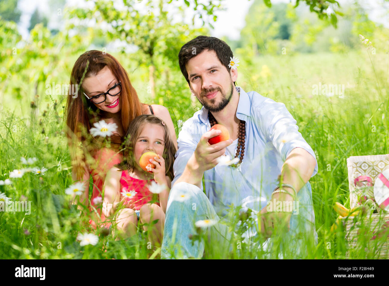 Family eating in summer meadow sitting on grass having a picnic Stock ...