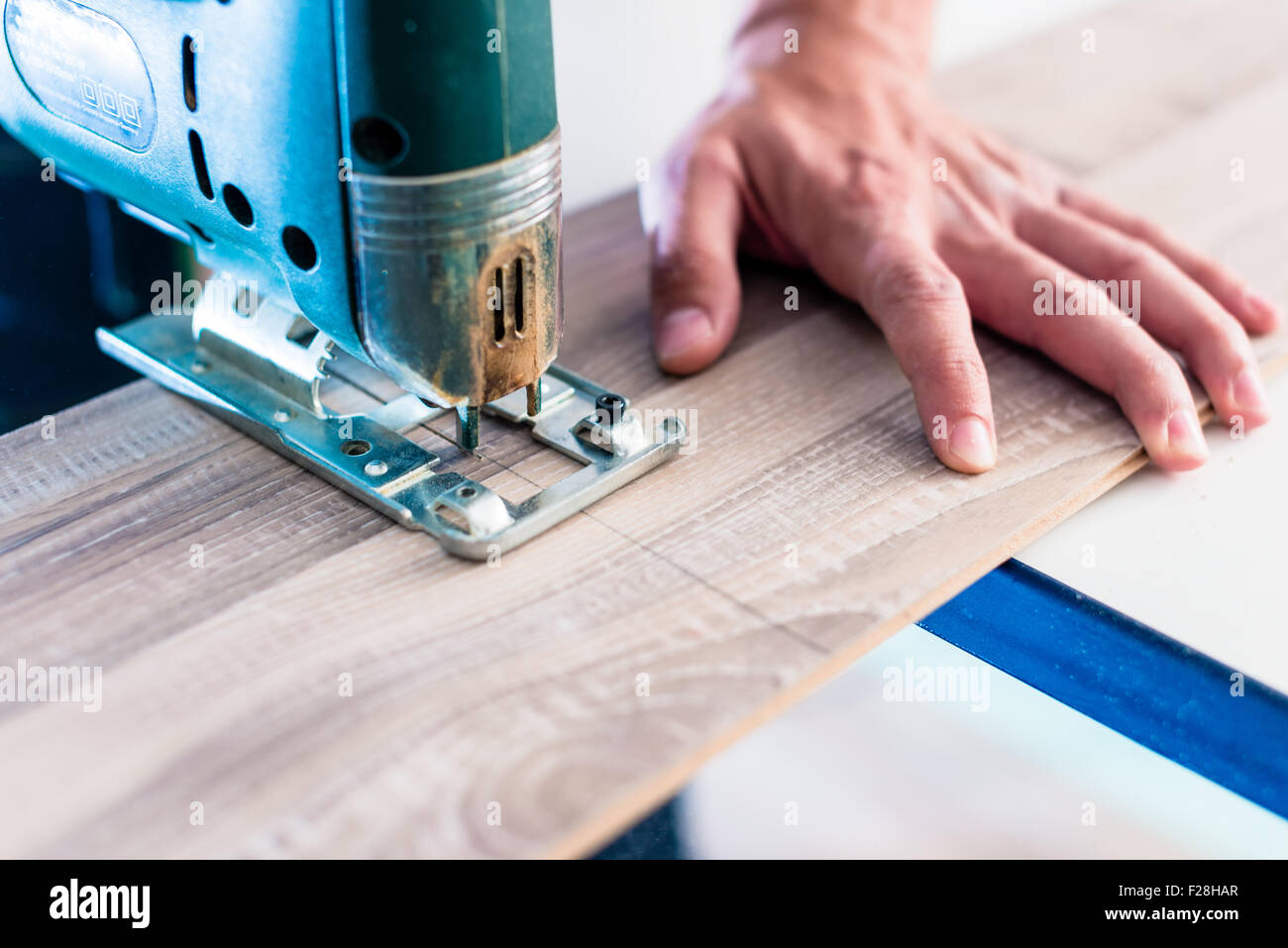 DIY worker cutting wooden panel with jig saw Stock Photo - Alamy