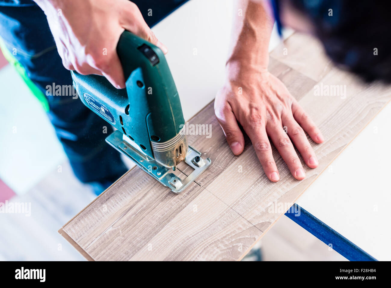 DIY worker cutting wooden panel with jig saw Stock Photo - Alamy