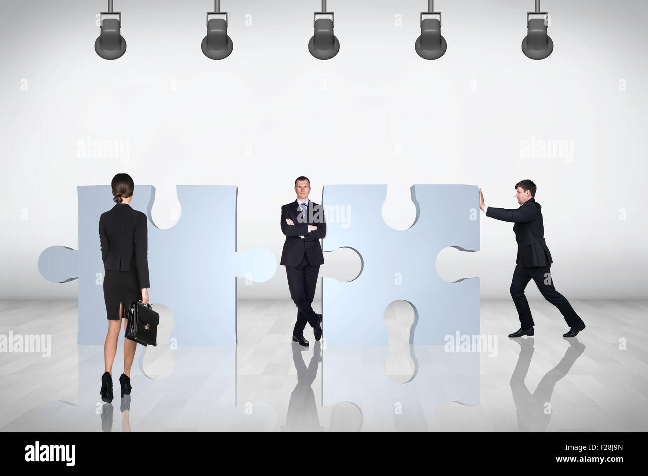 Team of business people try to join puzzle Stock Photo - Alamy