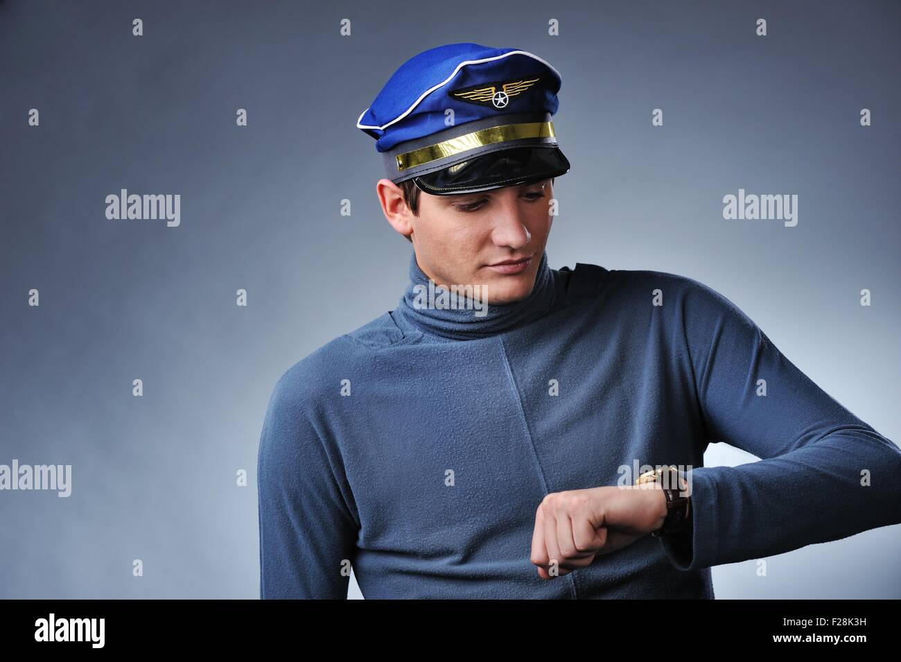 Handsome pilot looking to his watch. Isolated on grey background Stock ...